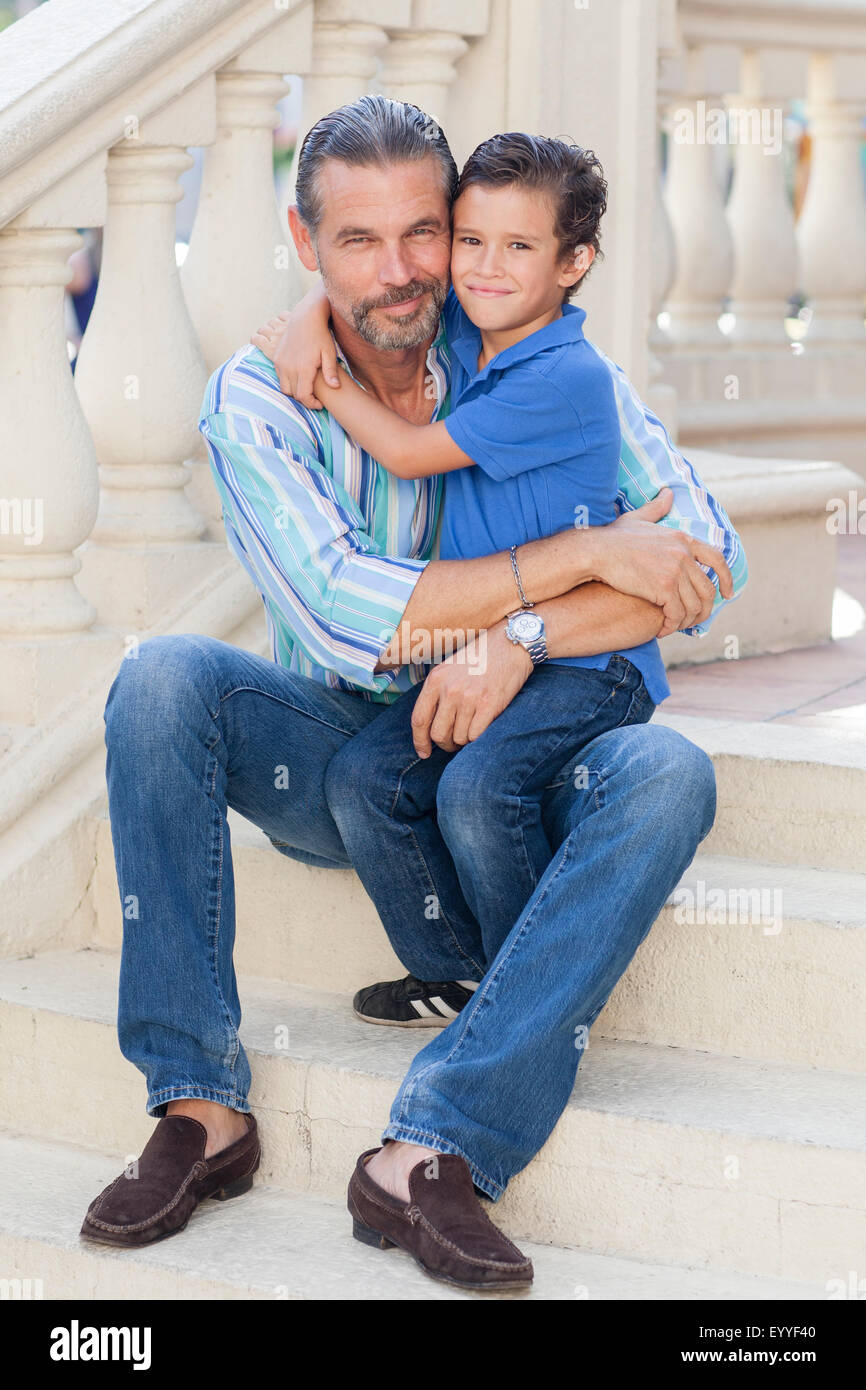 Caucasian father and son hugging on front stoop Stock Photo - Alamy
