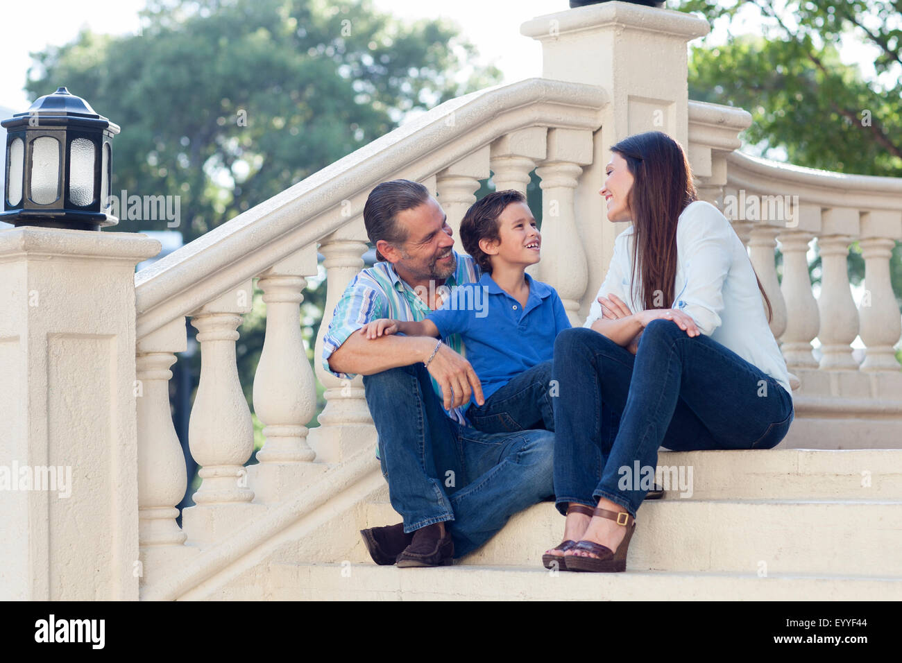 Caucasian mother, father and son relaxing on front stoop Stock Photo ...