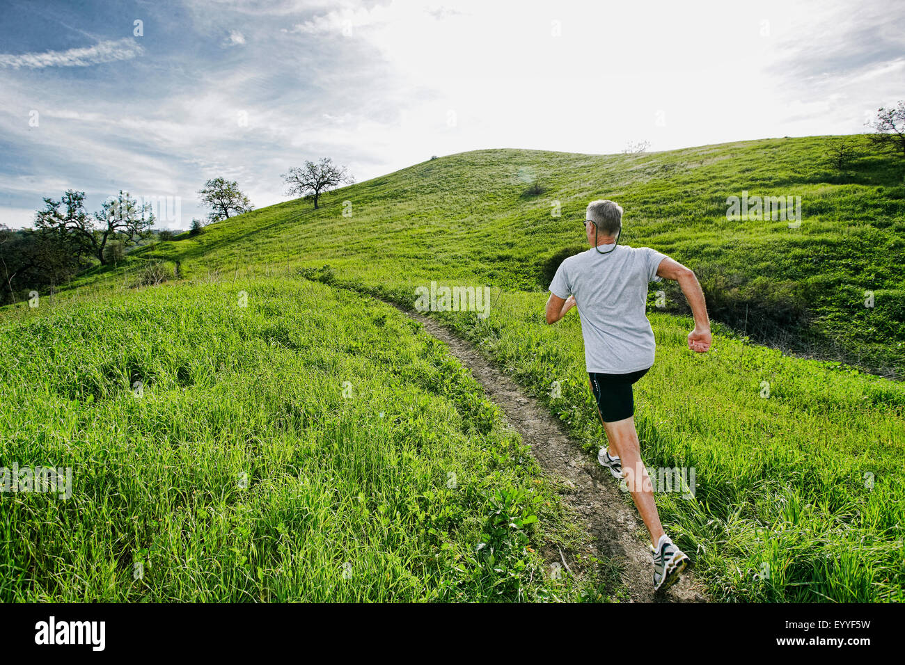 Older Caucasian man jogging on dirt path Stock Photo - Alamy