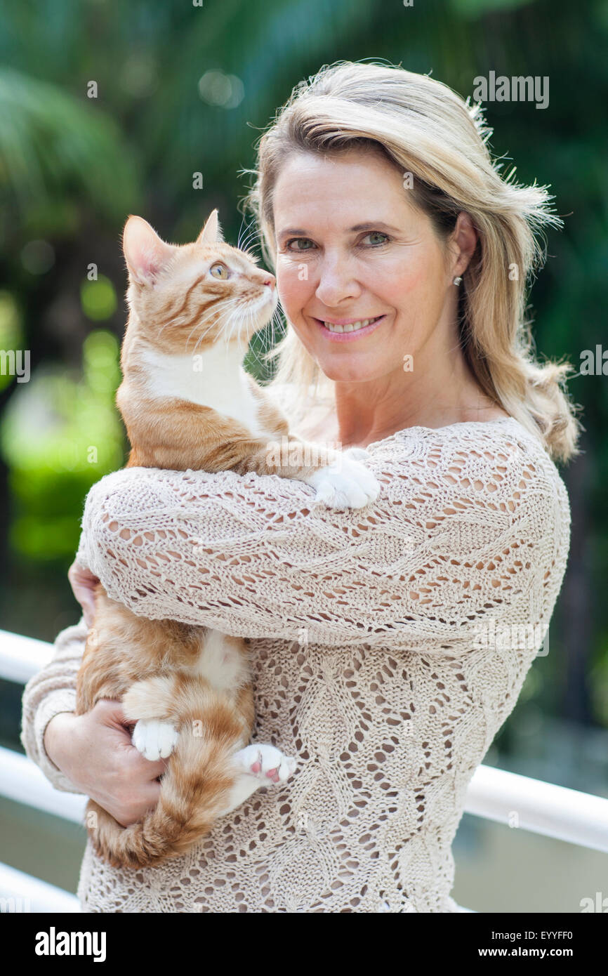Smiling Caucasian woman holding cat outdoors Stock Photo - Alamy