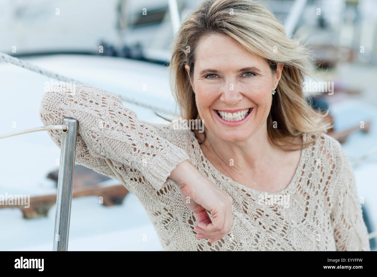 Caucasian woman leaning on boat in harbor Stock Photo - Alamy