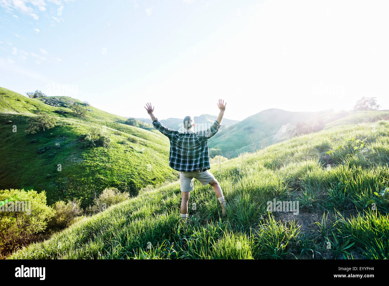 Older Caucasian man cheering on rural hillside Stock Photo - Alamy