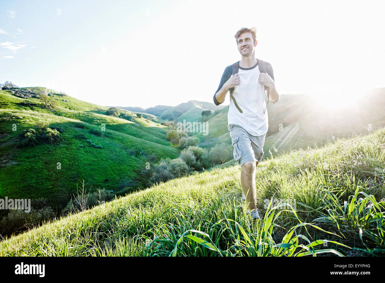 Caucasian man walking on rural hillside Stock Photo - Alamy