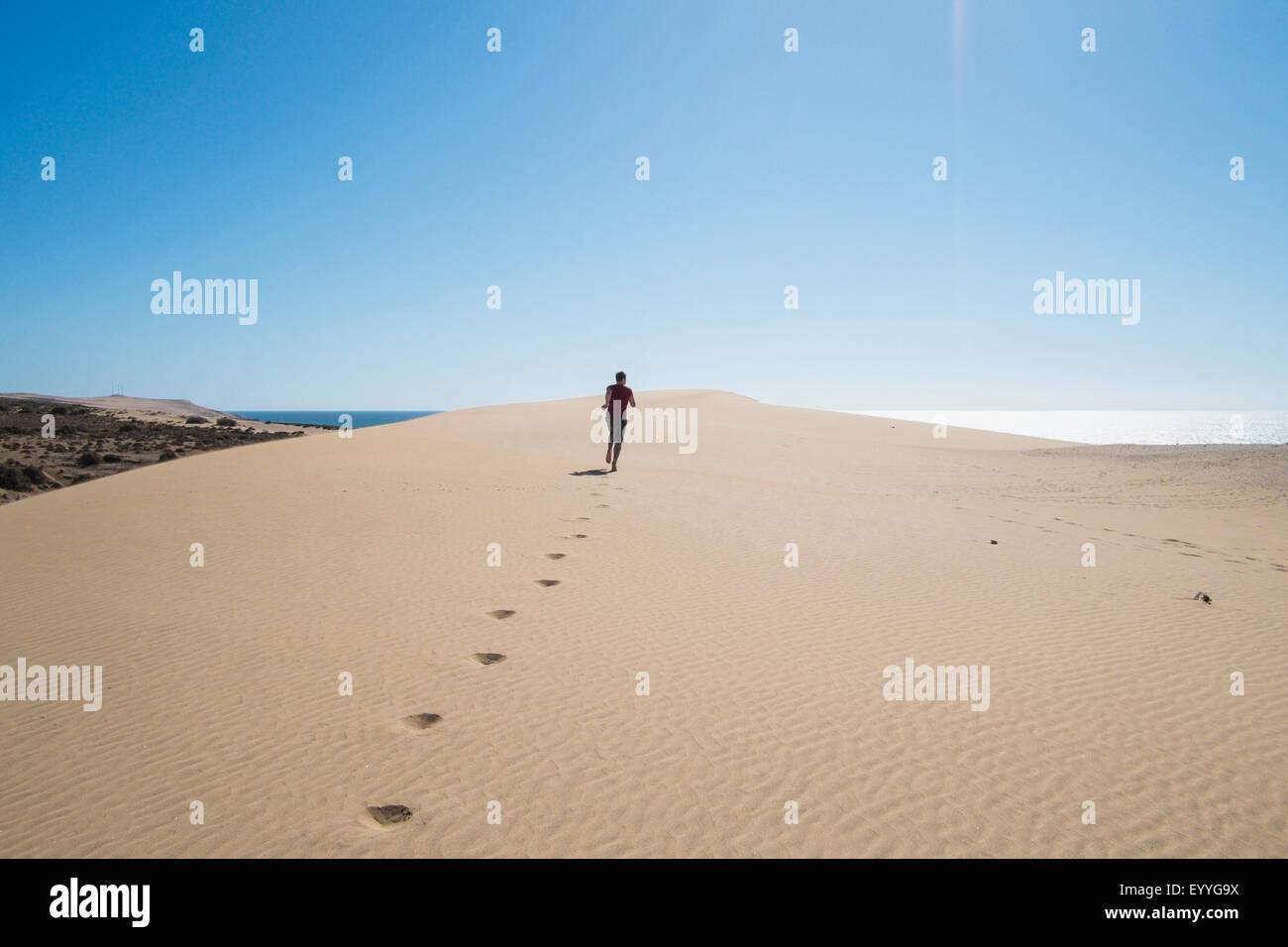Caucasian teenage boy running on sand dune Stock Photo - Alamy