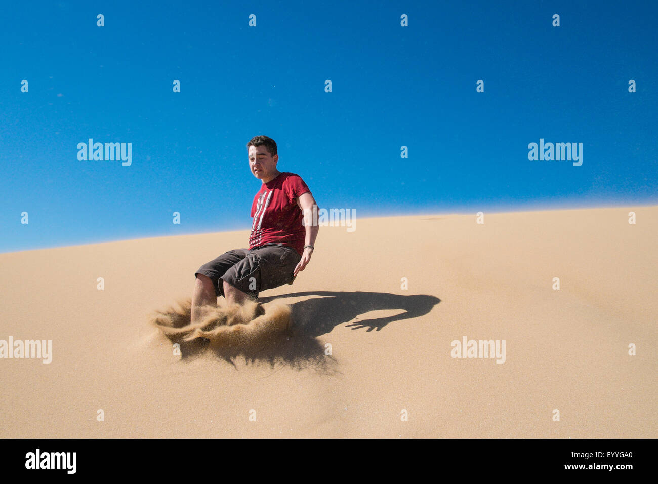 Caucasian teenage boy jumping on sand dune Stock Photo - Alamy