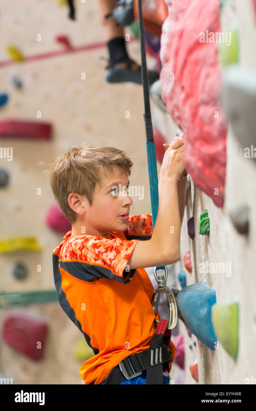 Caucasian boy climbing rock wall indoors Stock Photo - Alamy