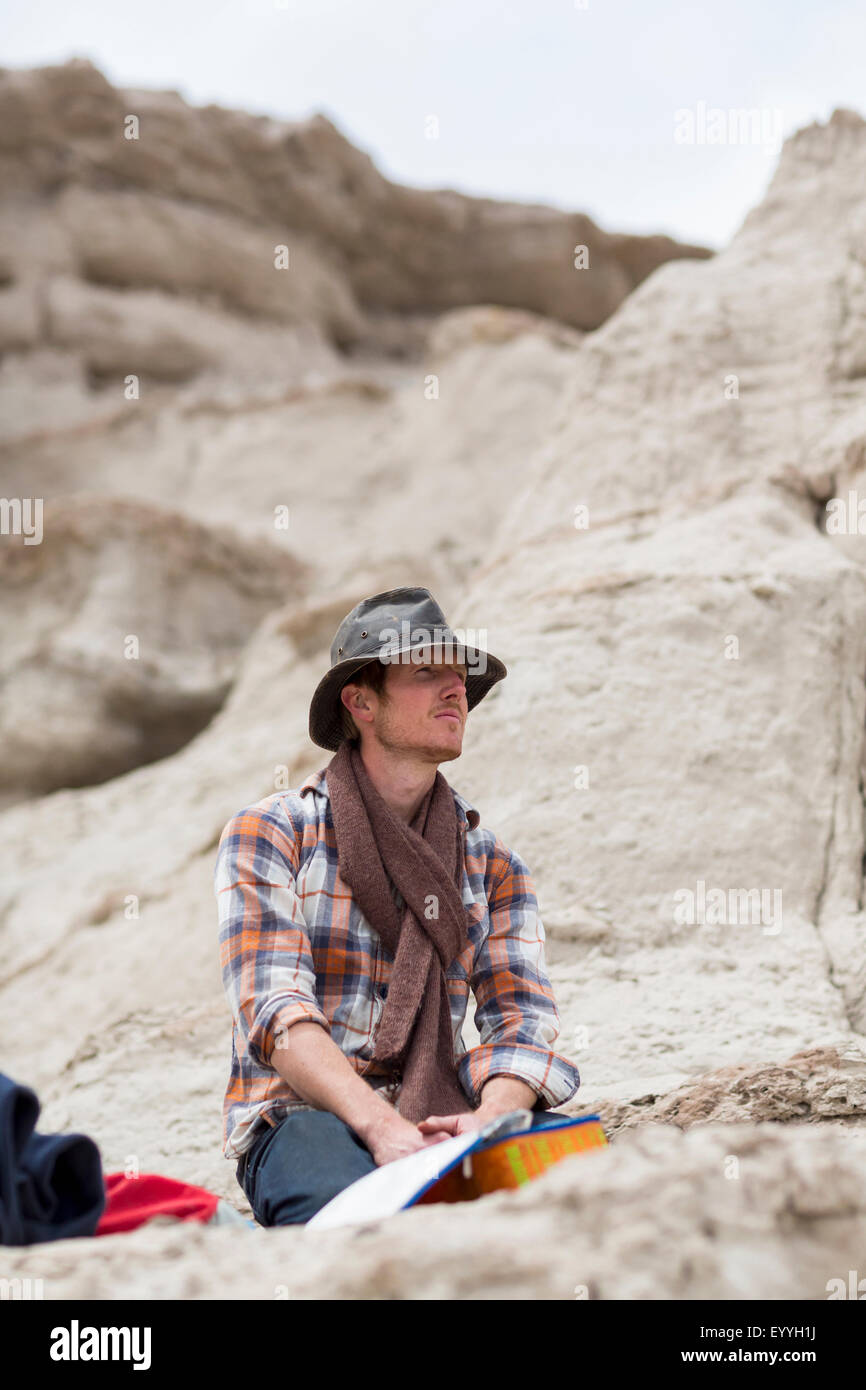Caucasian hiker sitting on rock formation in desert Stock Photo - Alamy