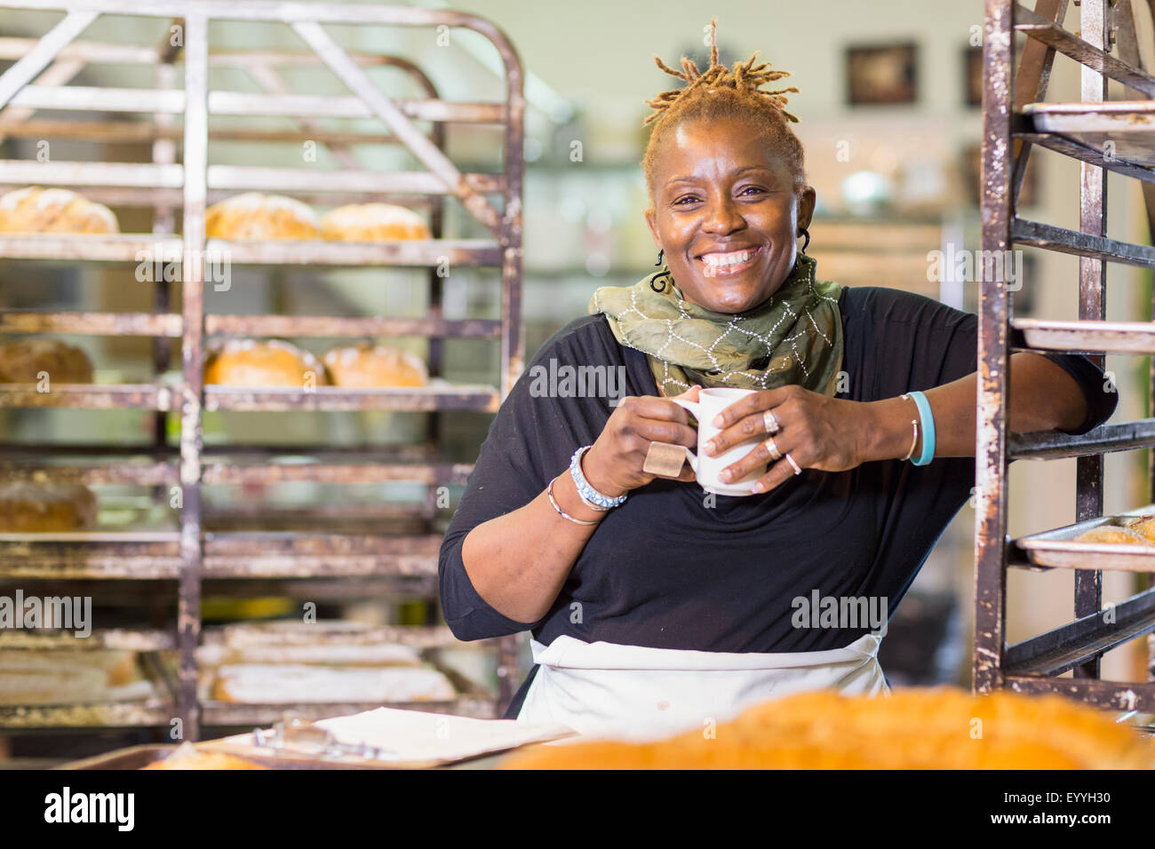 Black baker drinking coffee in bakery kitchen Stock Photo - Alamy