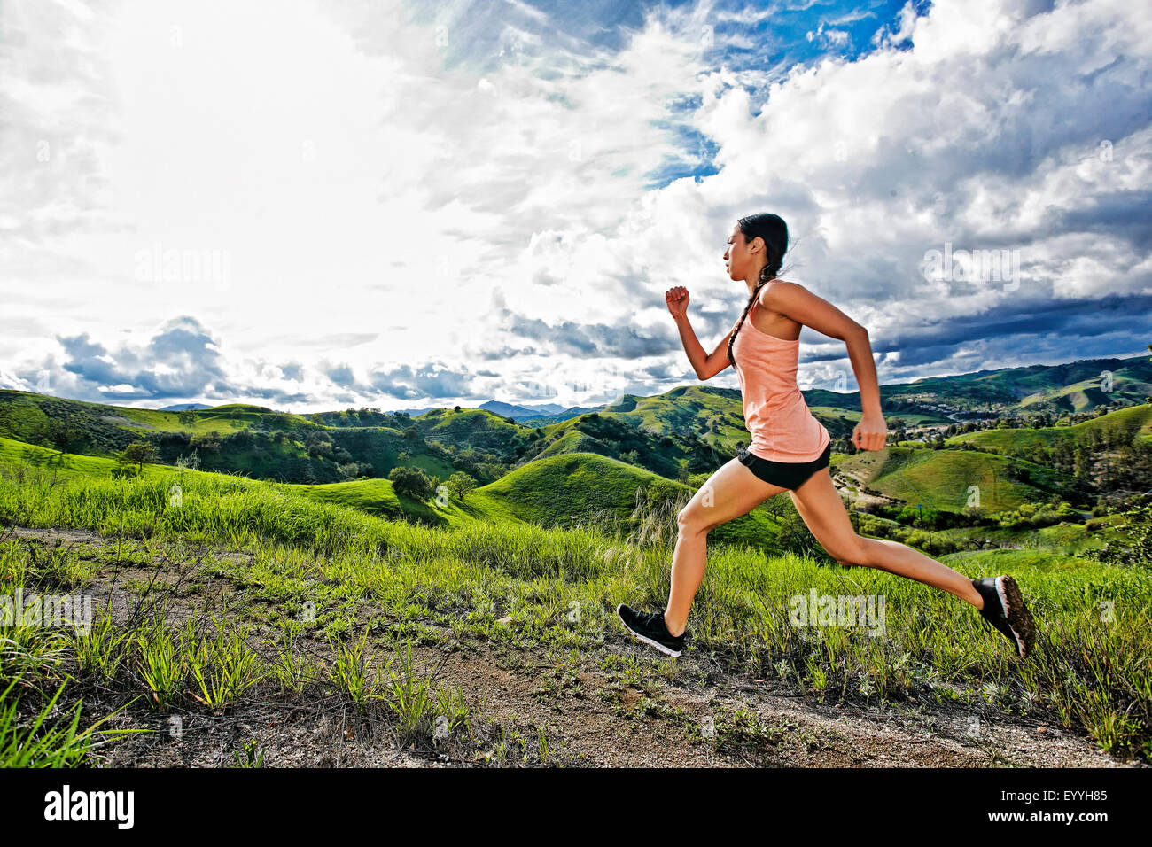Mixed race athlete running on rural hilltop Stock Photo - Alamy