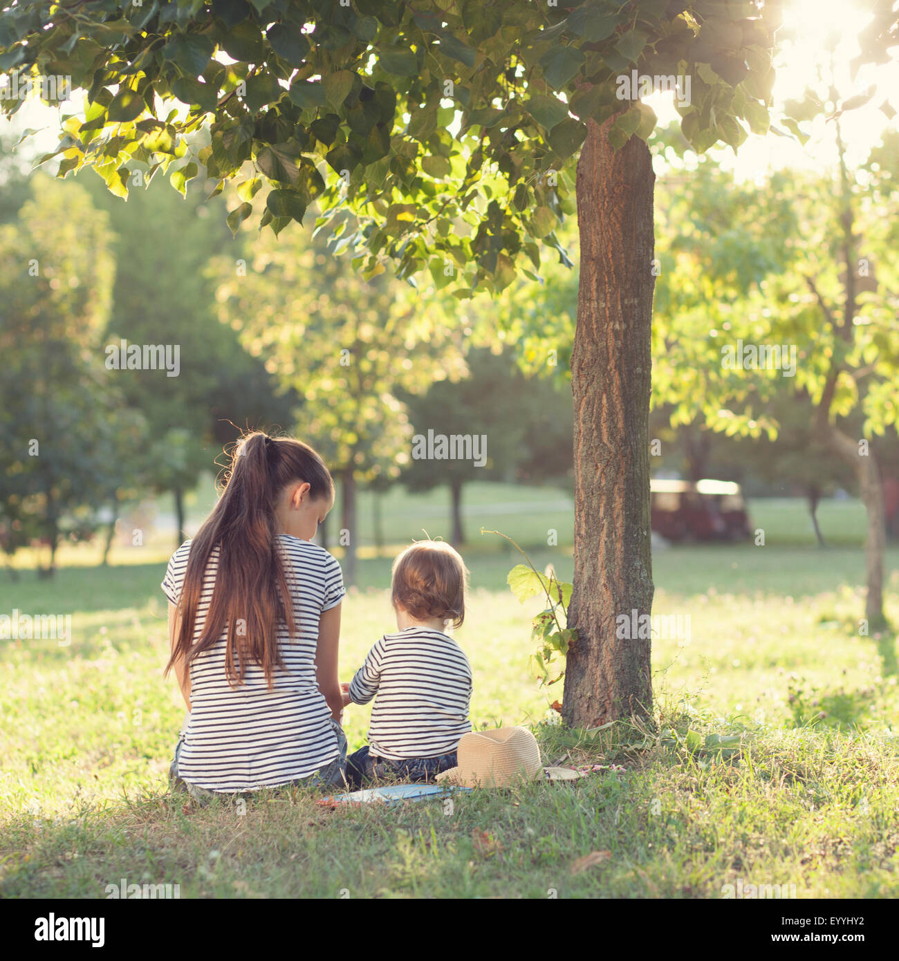 Mother and toddler sitting under the tree during summer leisure Stock ...