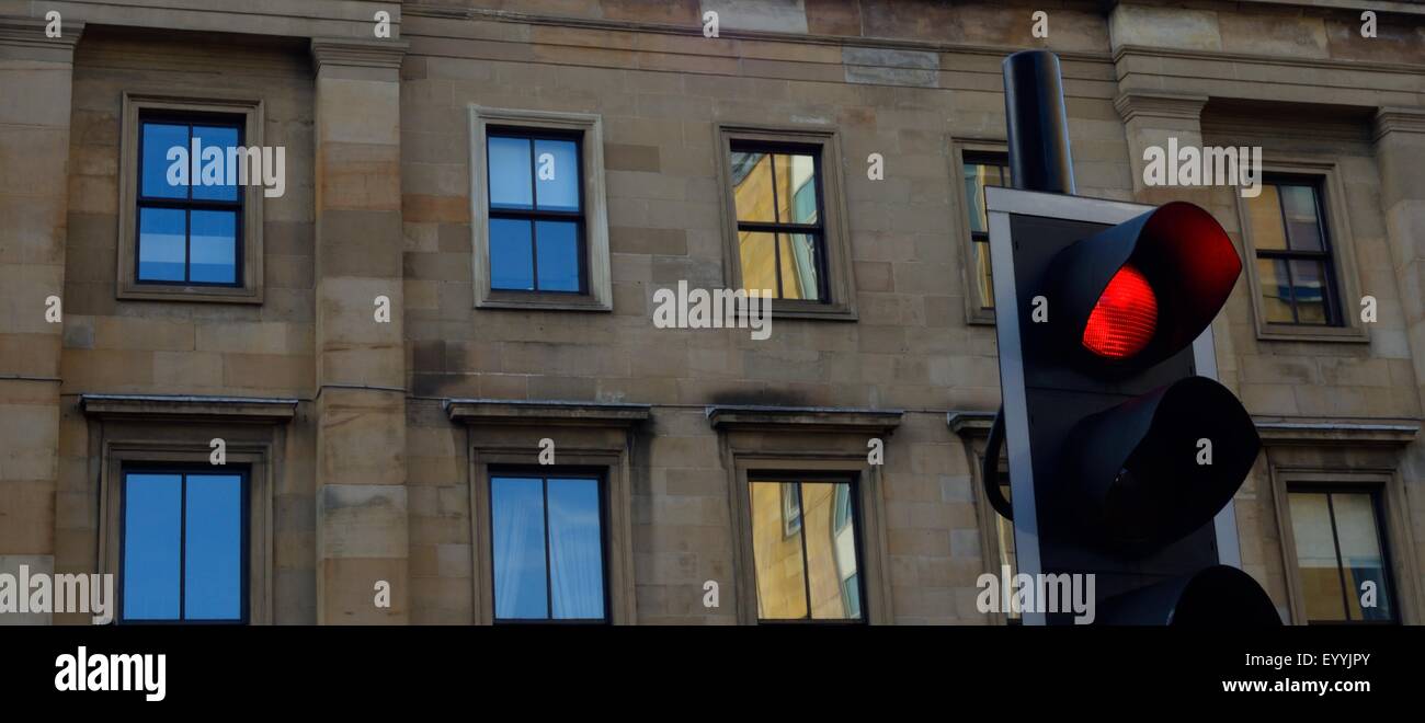 Red traffic light with stone building and reflections in windows Stock ...