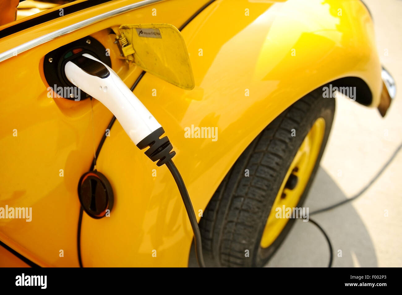 Detail shot with an electric plug in connected and charging a classic ...