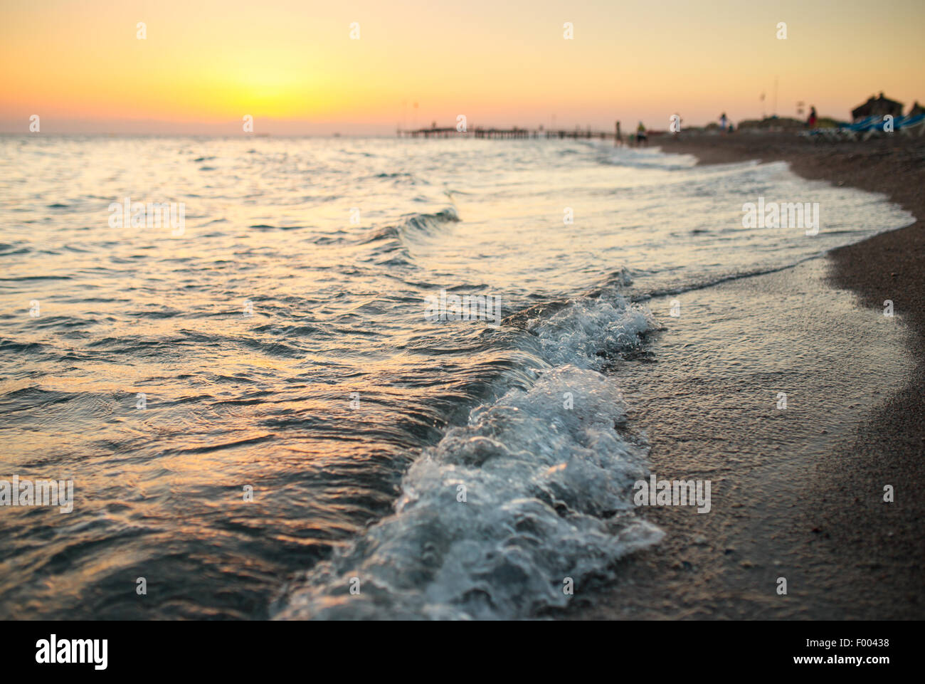 Shiny sea waves on the beach sand in sunset light Stock Photo - Alamy
