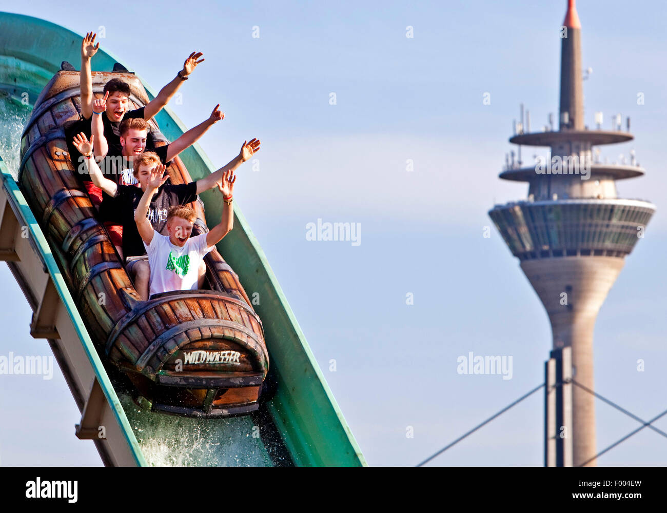 four young men on white-water ride, Rhine Tower in background, Germany ...