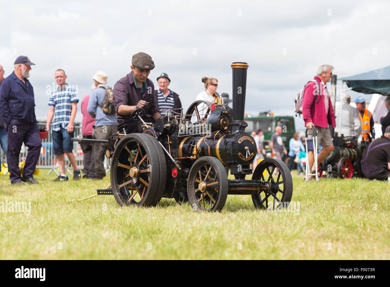 Man driving a mini traction engine at a steam fair in England Stock ...