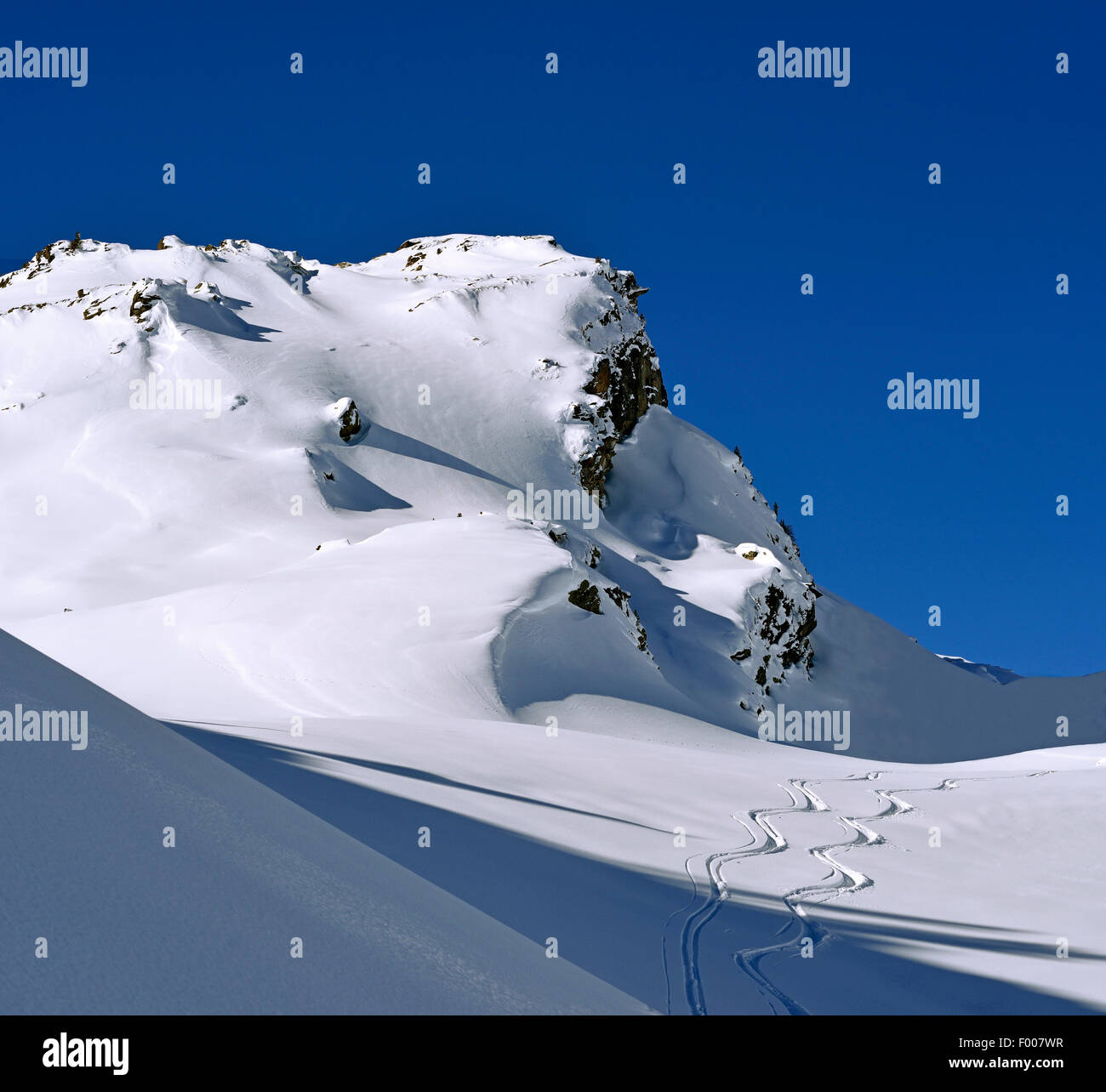 tracks of deep powder snow skiing at a mountain slope, France, Savoie ...