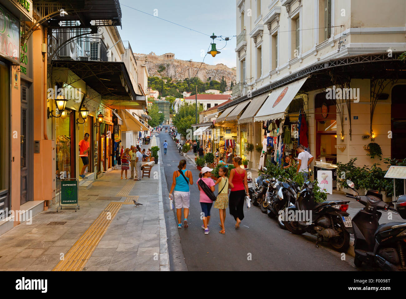 People in a street of the old town of Plaka and a view of Acropolis ...