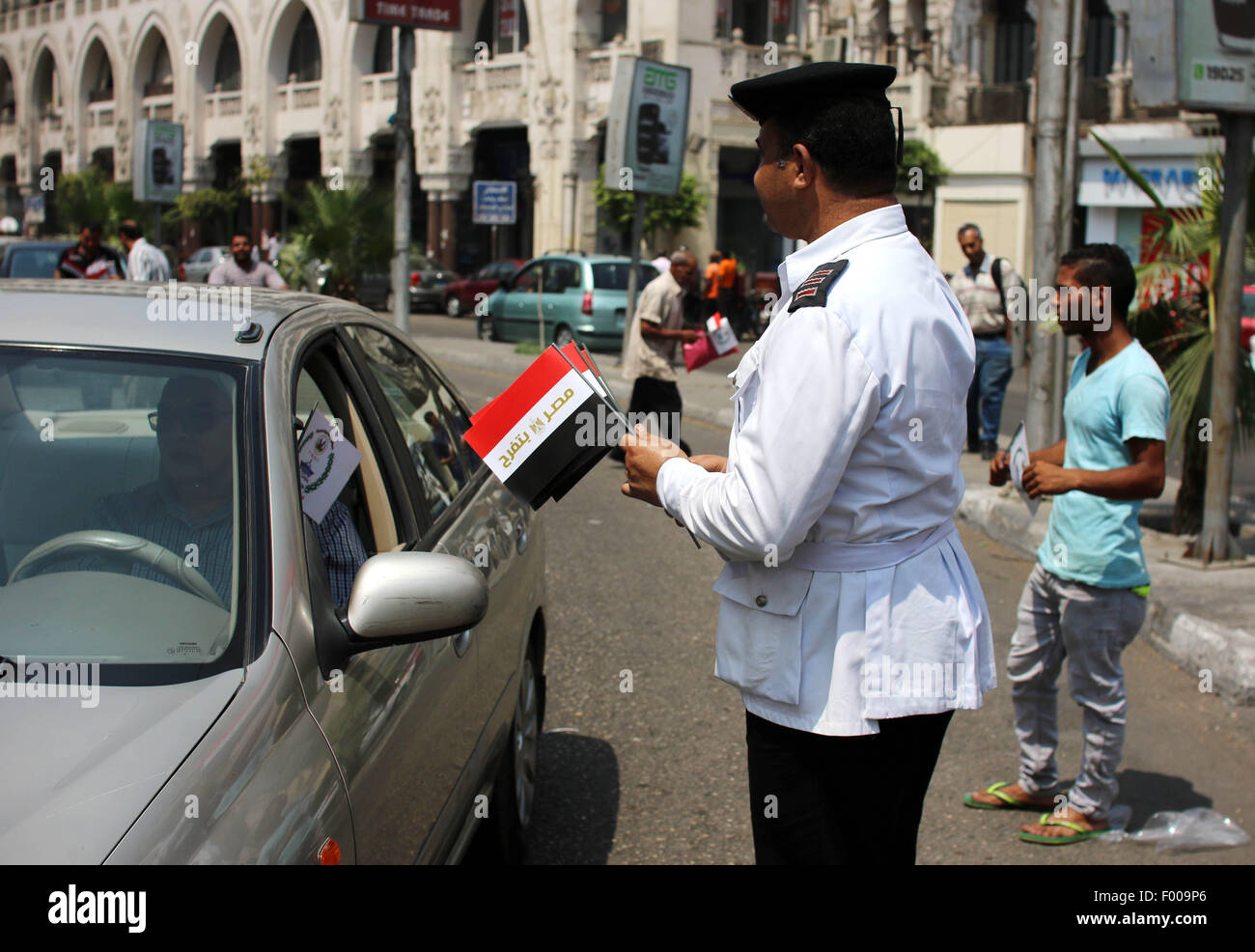 Cairo, Egypt. 5th Aug, 2015. An Egyptian police officer distributes ...