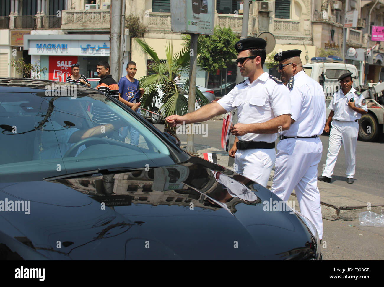 Cairo, Egypt. 5th Aug, 2015. An Egyptian police officer distributes ...