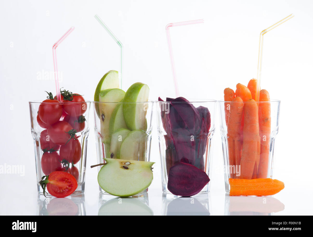 Conceptual image - fresh fruits and vegetables in glass cups on a white ...