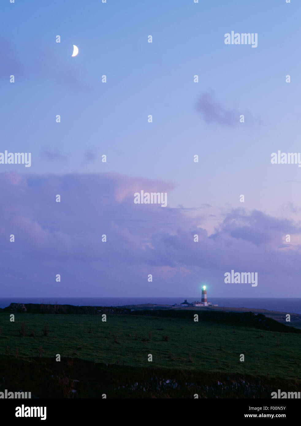 Bardsey Island lighthouse, Gwynedd, lit at twilight looking SW with ...
