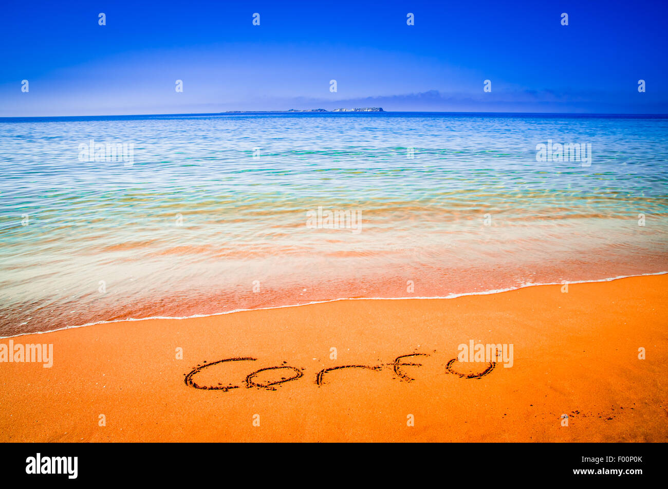 Corfu word written on a sandy golden beach, Greece. Selective focus ...
