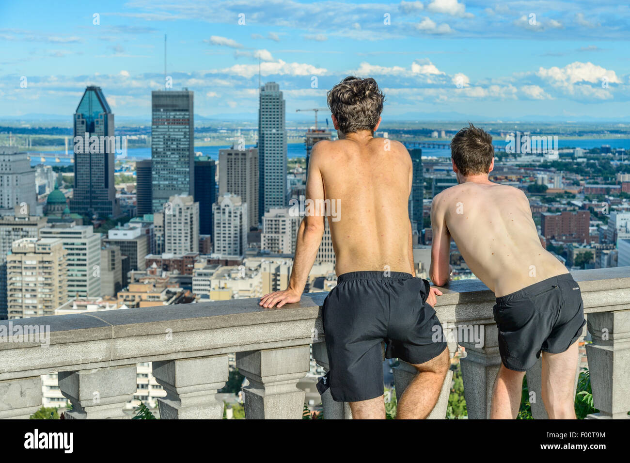 2 shirtless young men are looking at Montreal skyline from Kondiaronk ...