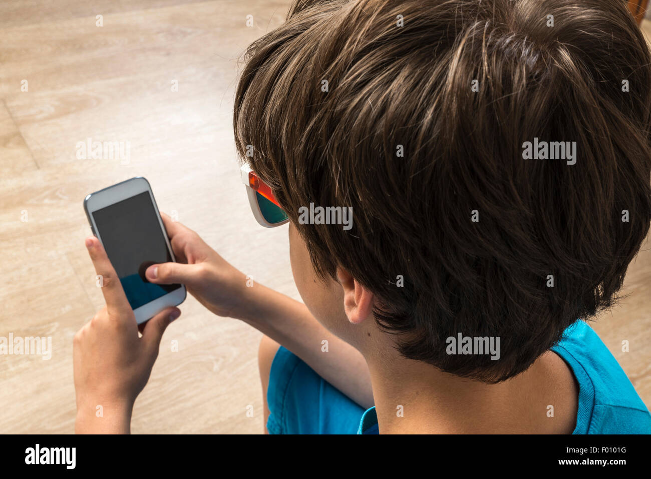 Boy touching a mobile phone with his back to camera Stock Photo - Alamy