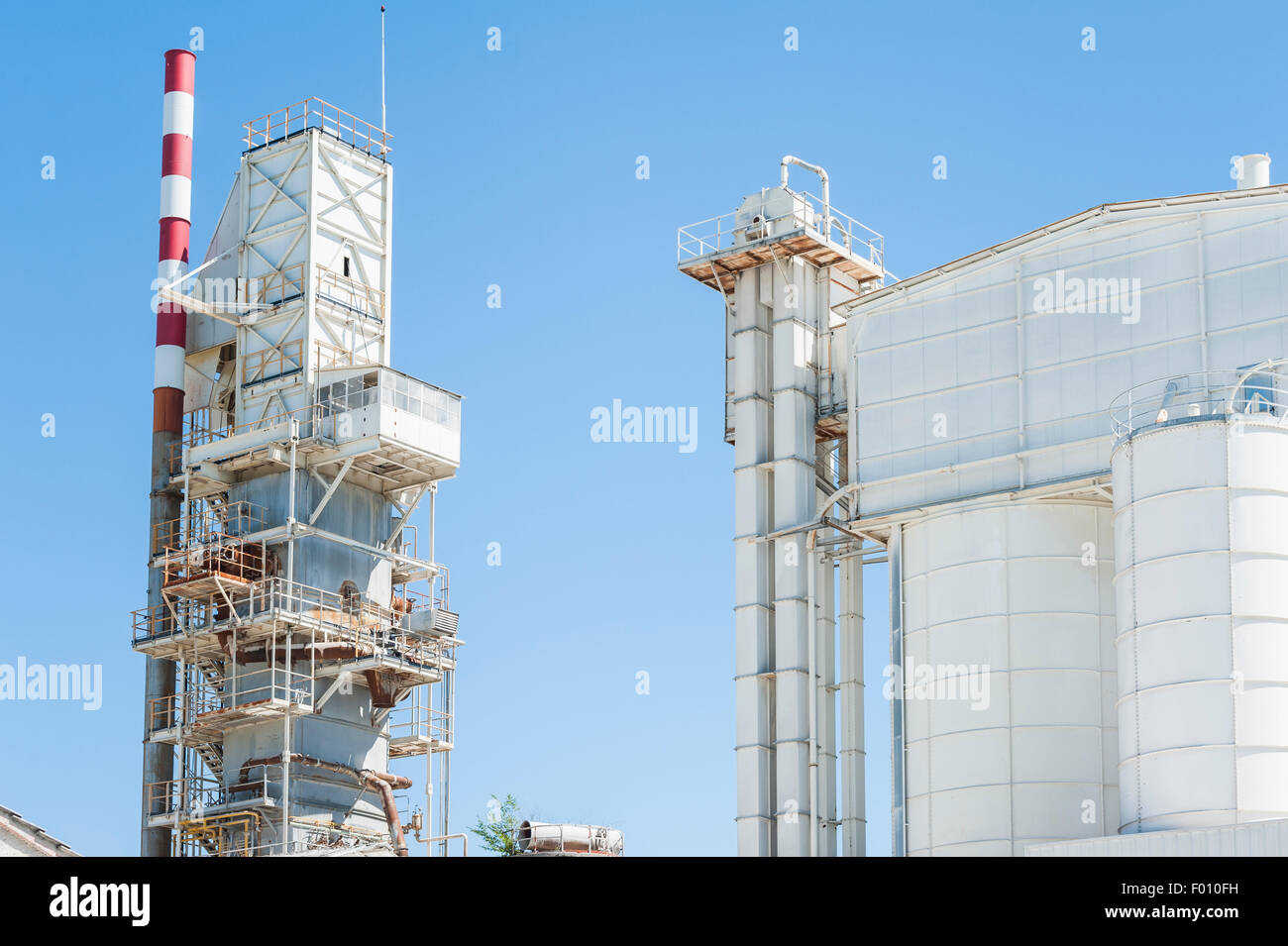 Old cement plant. Preheating tower and storage silos Stock Photo - Alamy