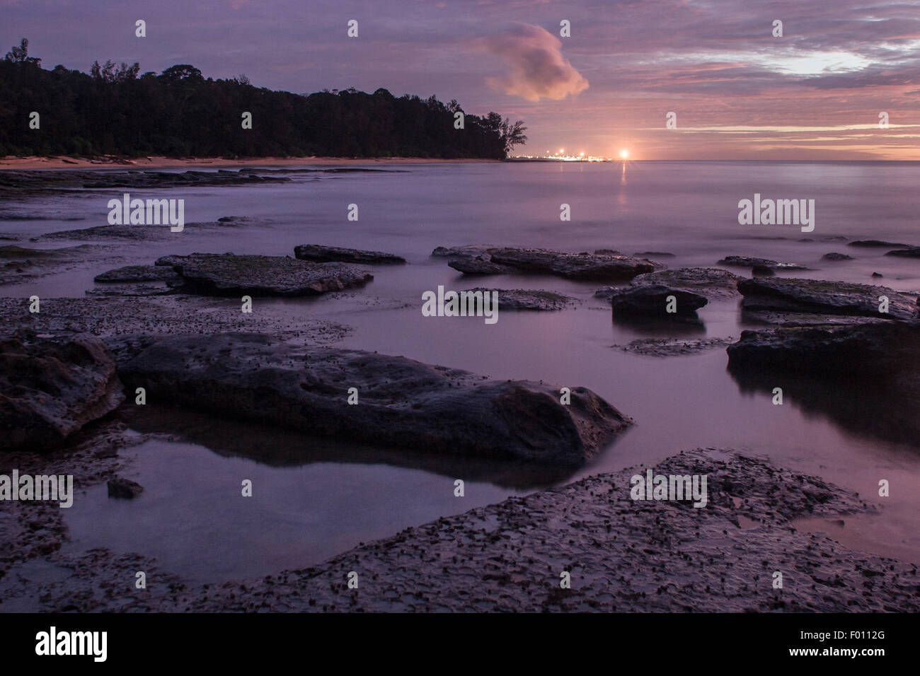 Sunset on the beach; natural gas complex in the background. Similajau ...