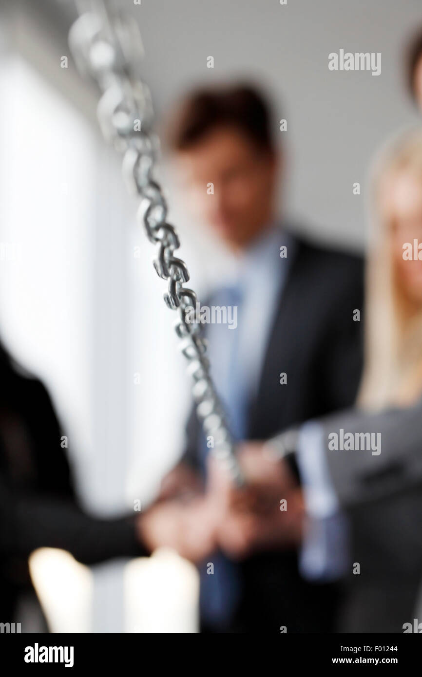 Businessmen pulling chain Stock Photo - Alamy