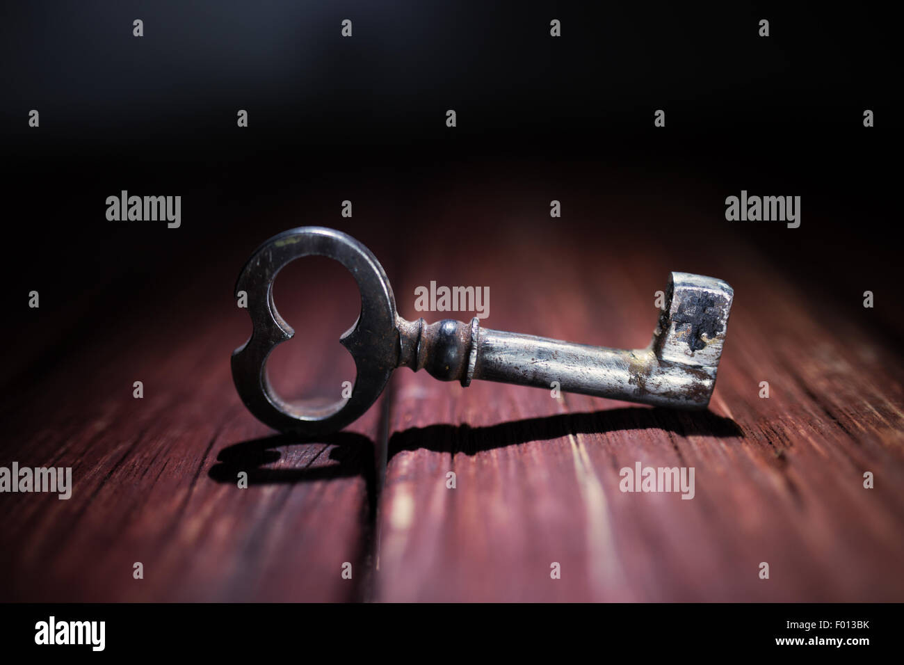 Rusty key on old wooden surface Stock Photo - Alamy