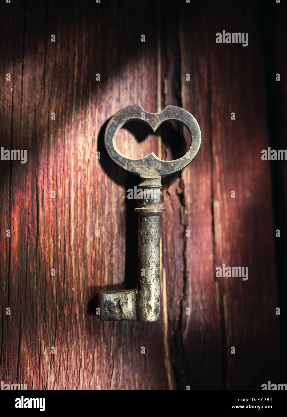 Rusty key on old wooden surface Stock Photo - Alamy