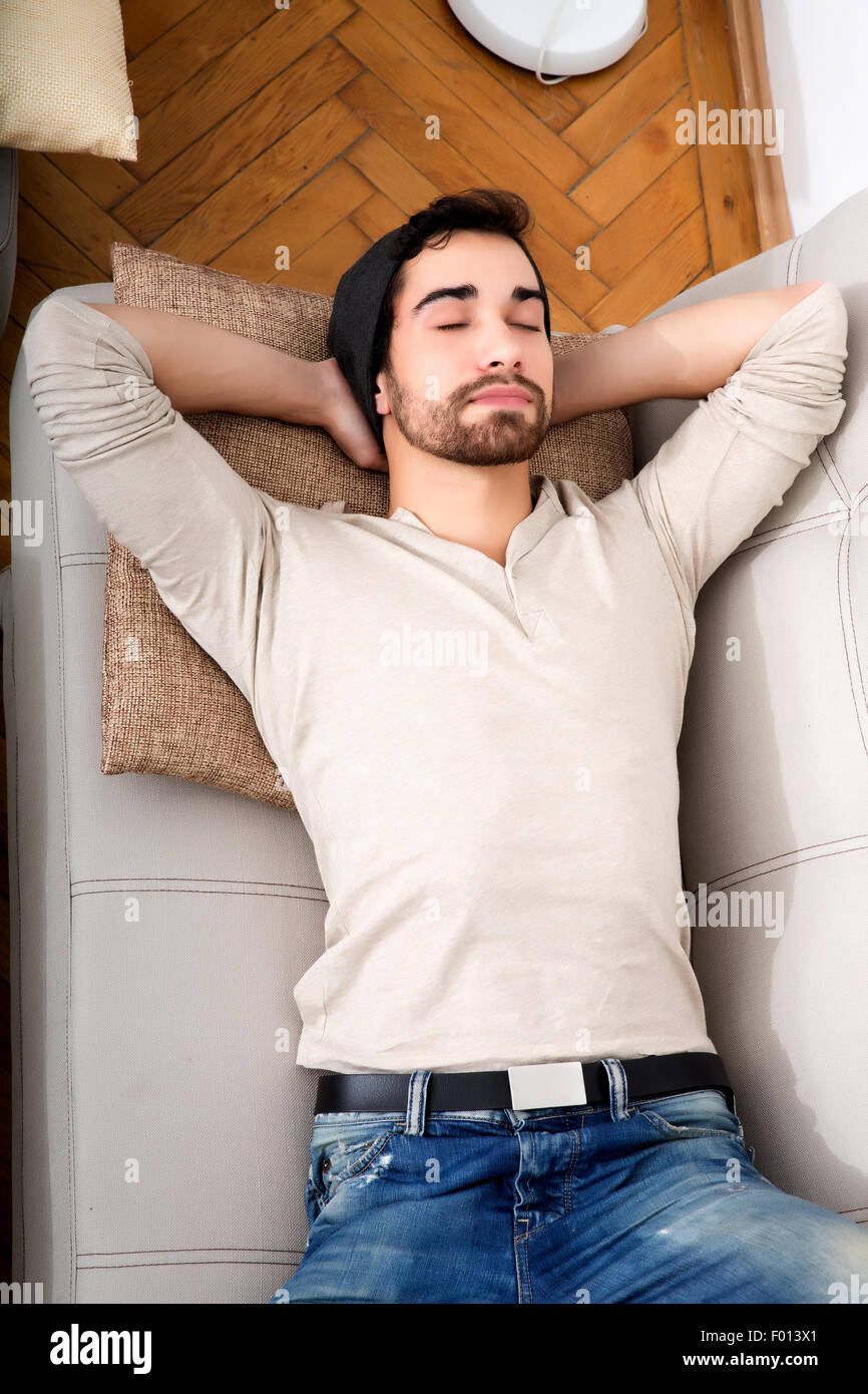 Young man relaxing on the sofa at home Stock Photo - Alamy
