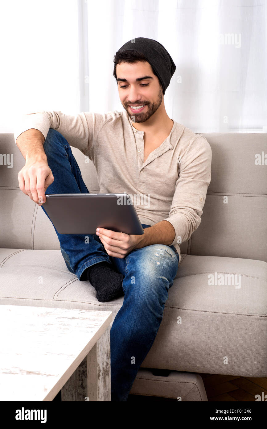 Portrait of a handsome young man using a tablet pc at home Stock Photo ...