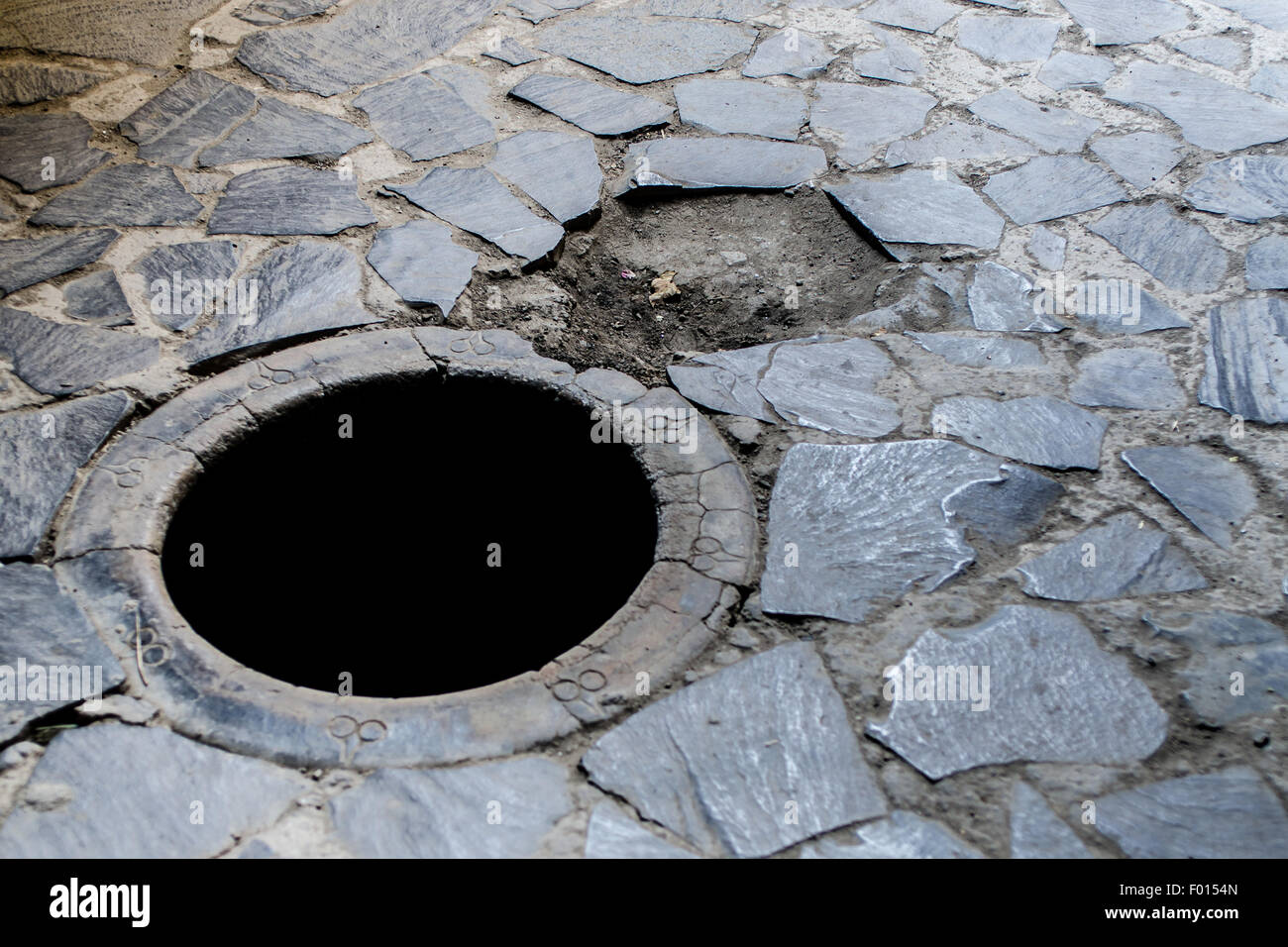 Open manhole surrounded by cobblestones creates a safety hazard in an ...