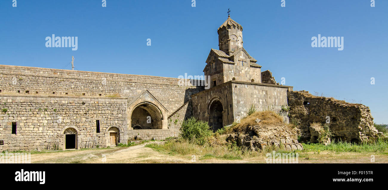 Historic stone monastery in a serene landscape under a clear blue sky ...