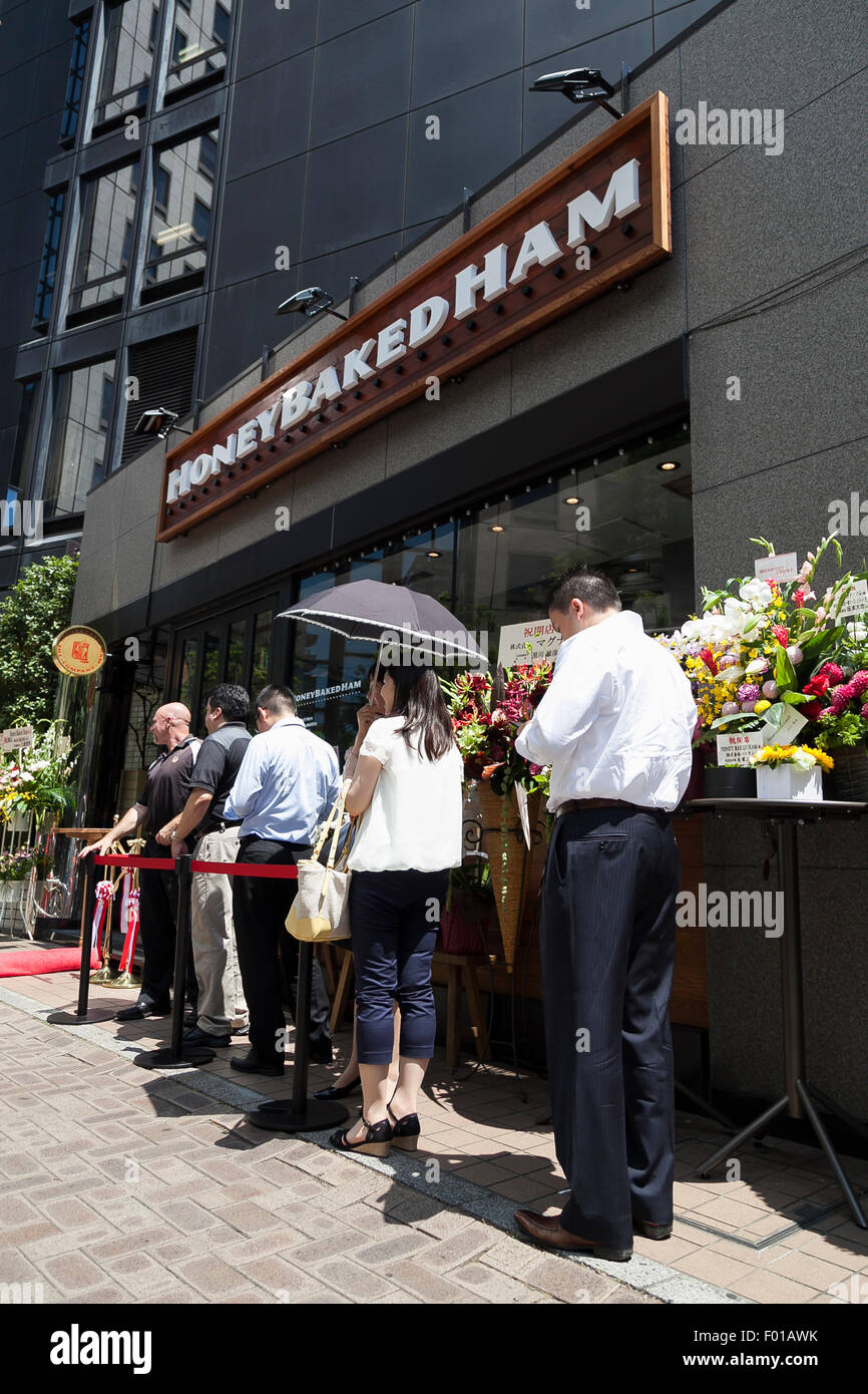 Customers wait outside the new Honey Baked Ham store in Tokyo, Japan on ...