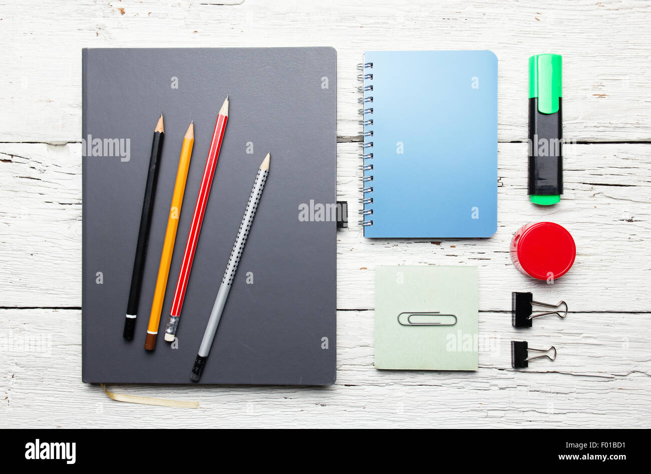 Workplace. White wooden table with notepad, colorful pencils and ...