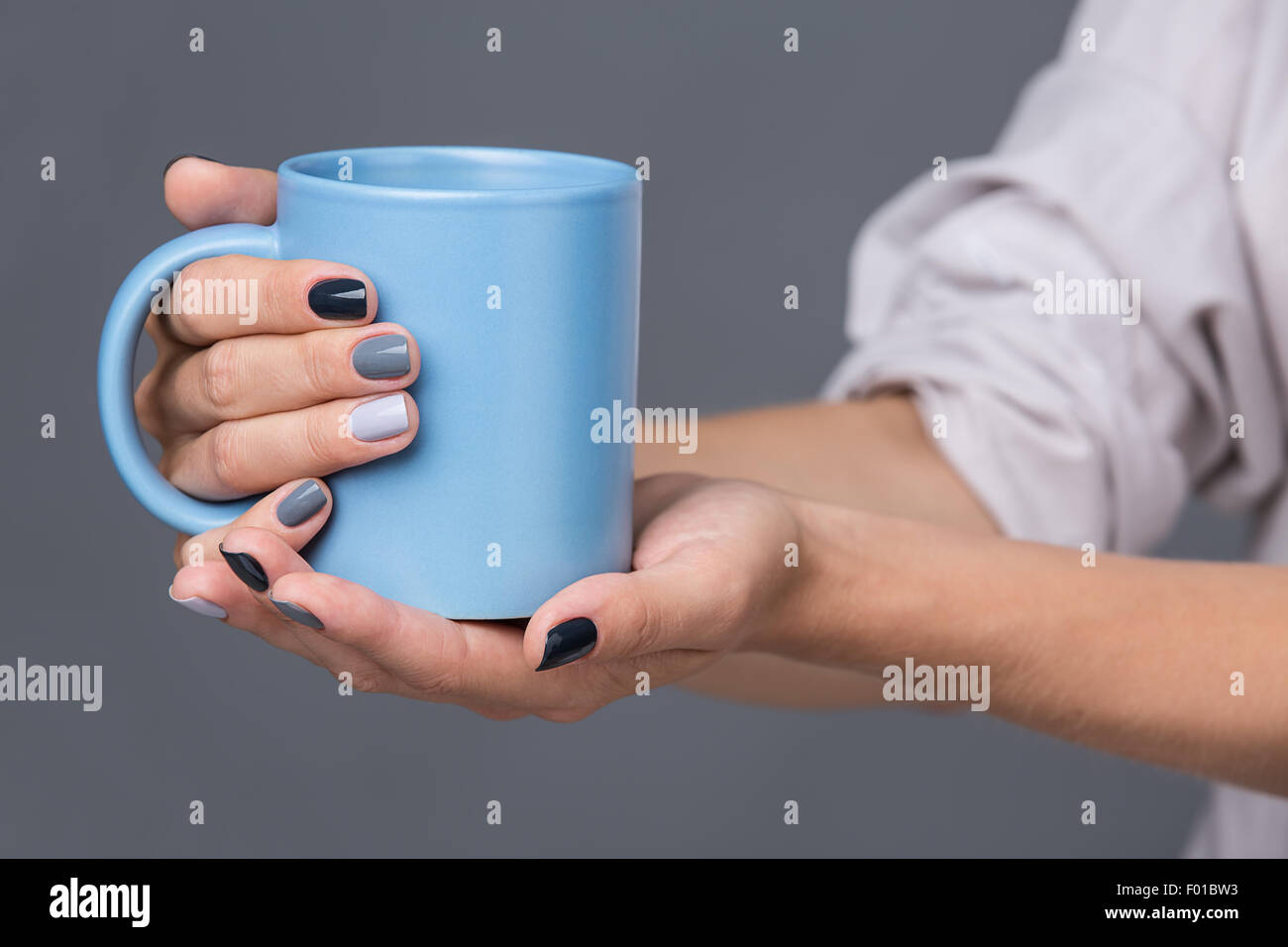 Female hands with blue cup Stock Photo - Alamy