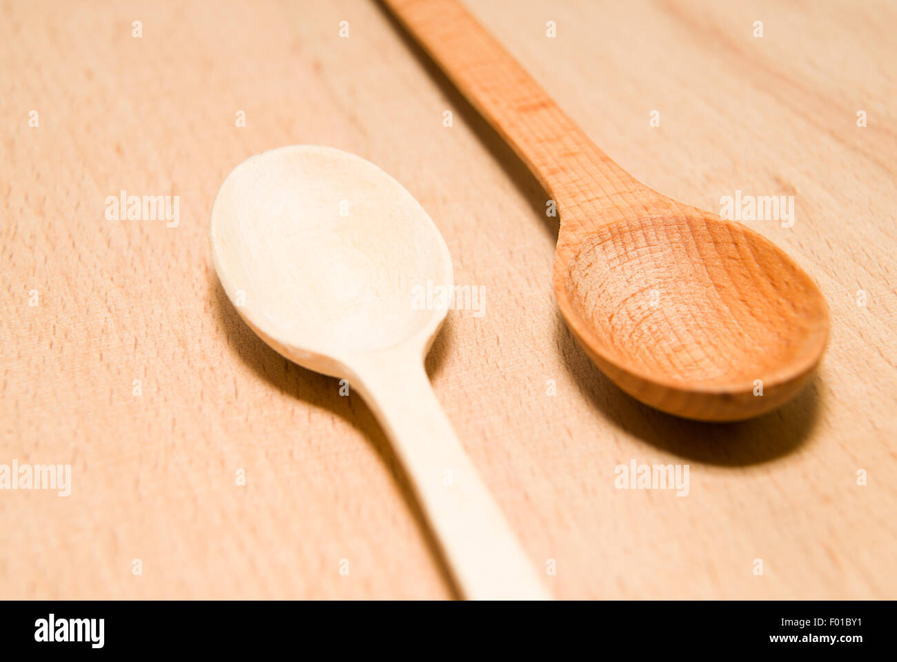 Two wooden spoons of different colors are on the surface Stock Photo ...