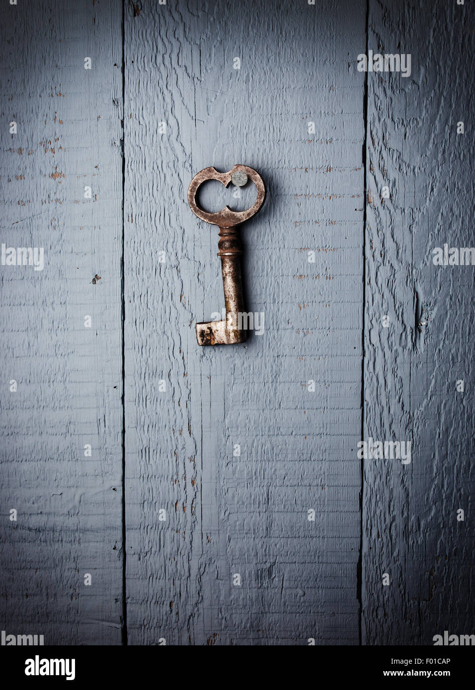 Rusty key on old wooden surface Stock Photo - Alamy