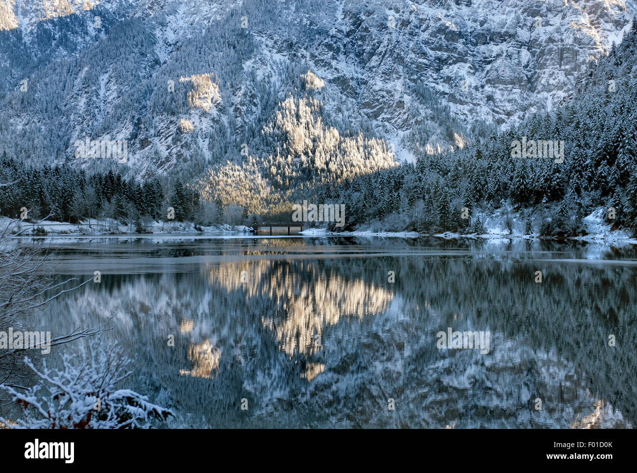 A picturesque winter reflection scene, in a partly frozen lake, Austria ...