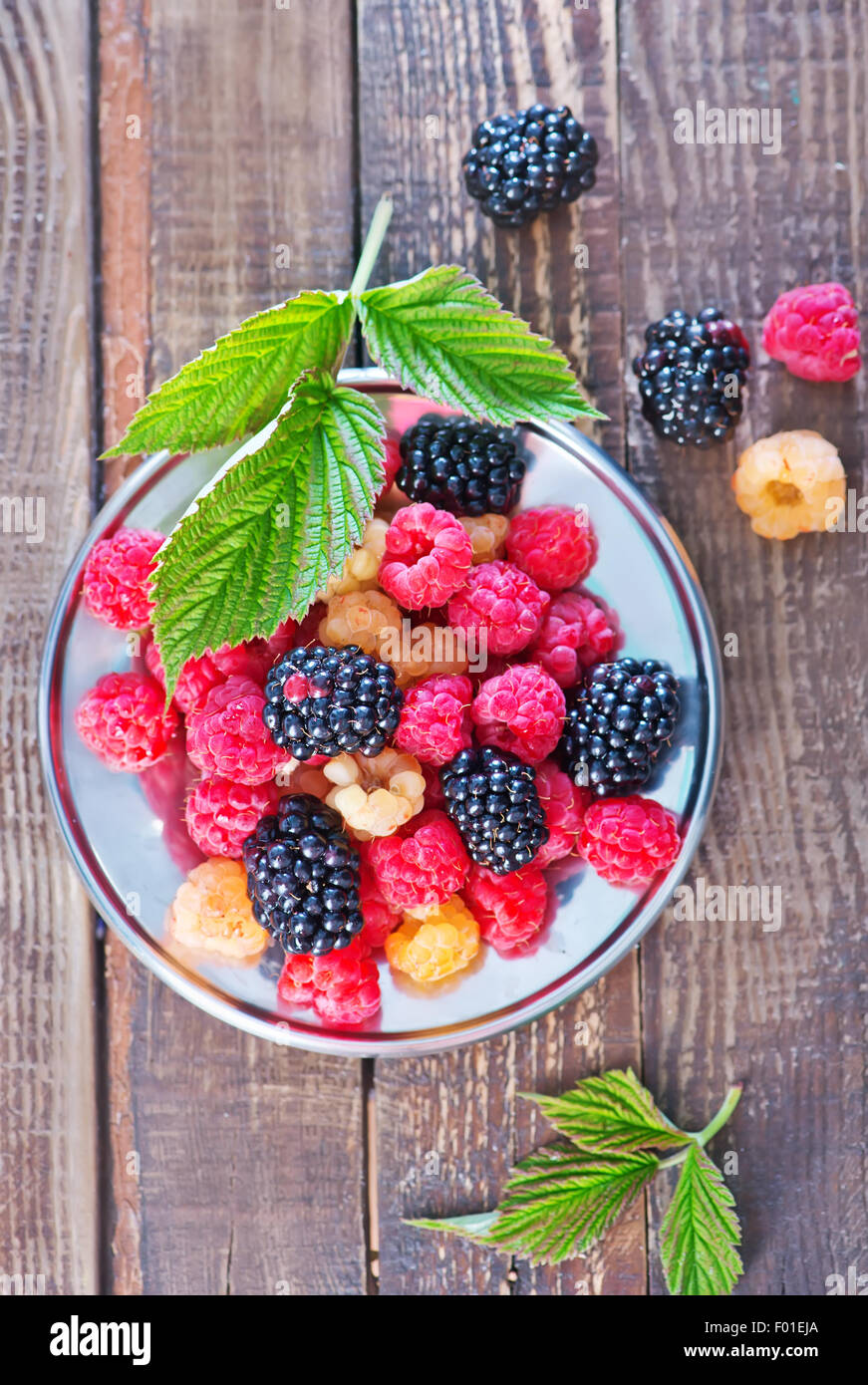 mix berries on plate and on a table Stock Photo - Alamy