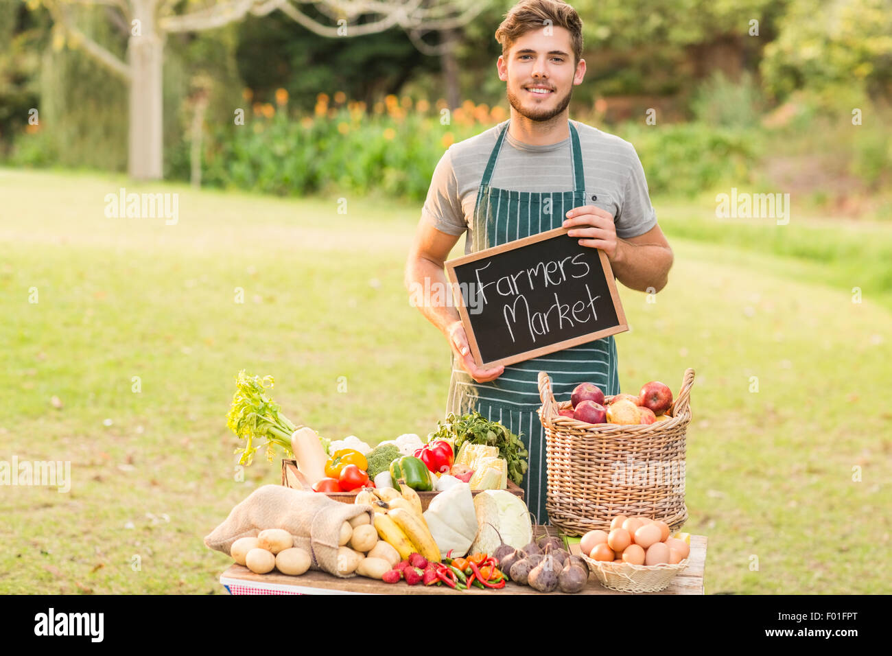 Handsome farmer standing at his stall and holding chalkboard Stock ...