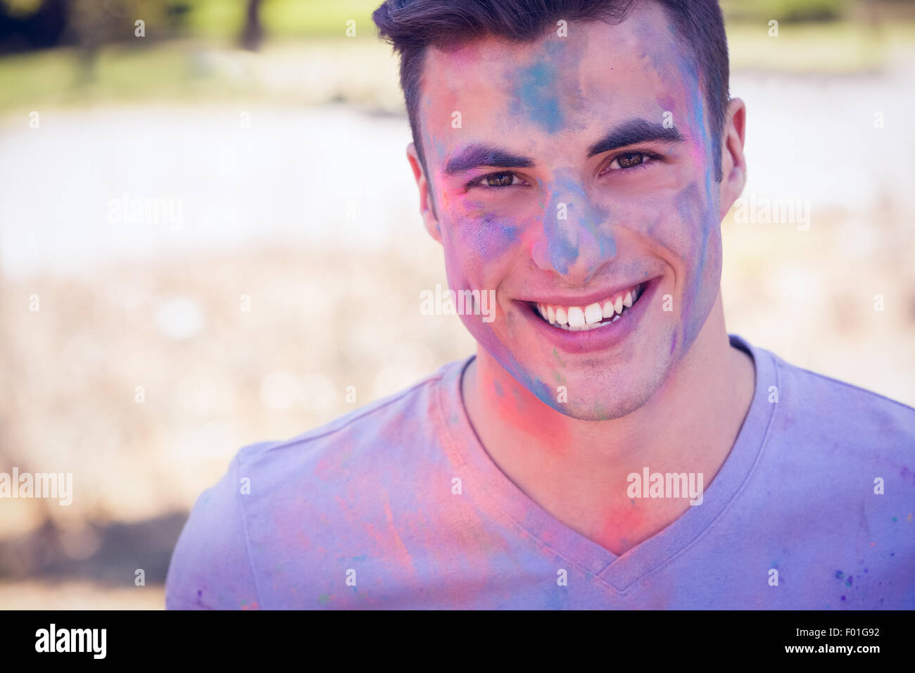 Handsome man covered with powder paint in the park Stock Photo - Alamy