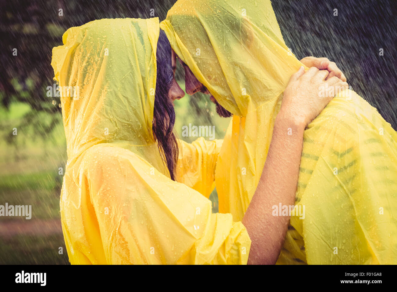 Cute couple wearing protection cape and hugging under the rain Stock ...