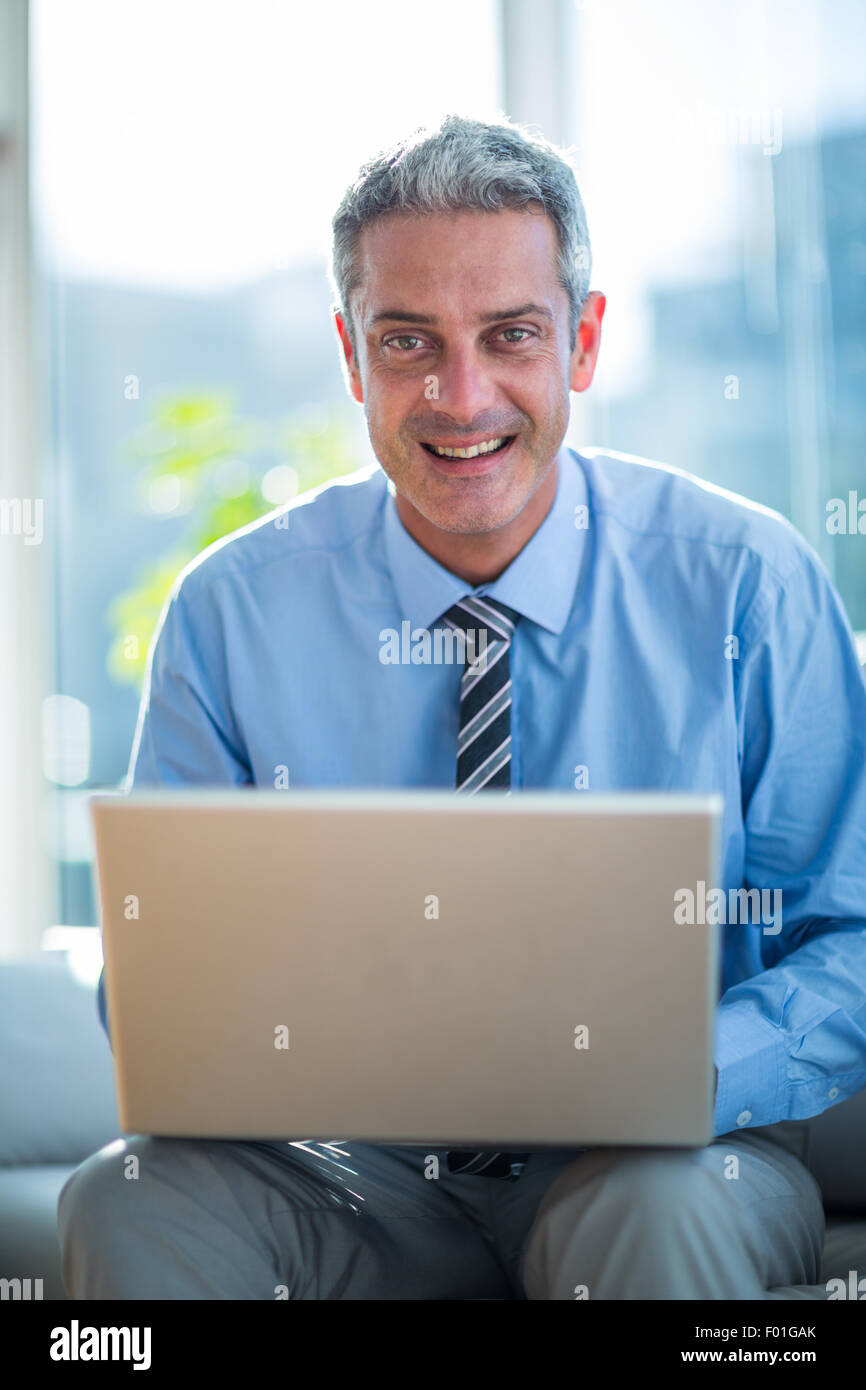 Happy businessman using laptop computer Stock Photo - Alamy