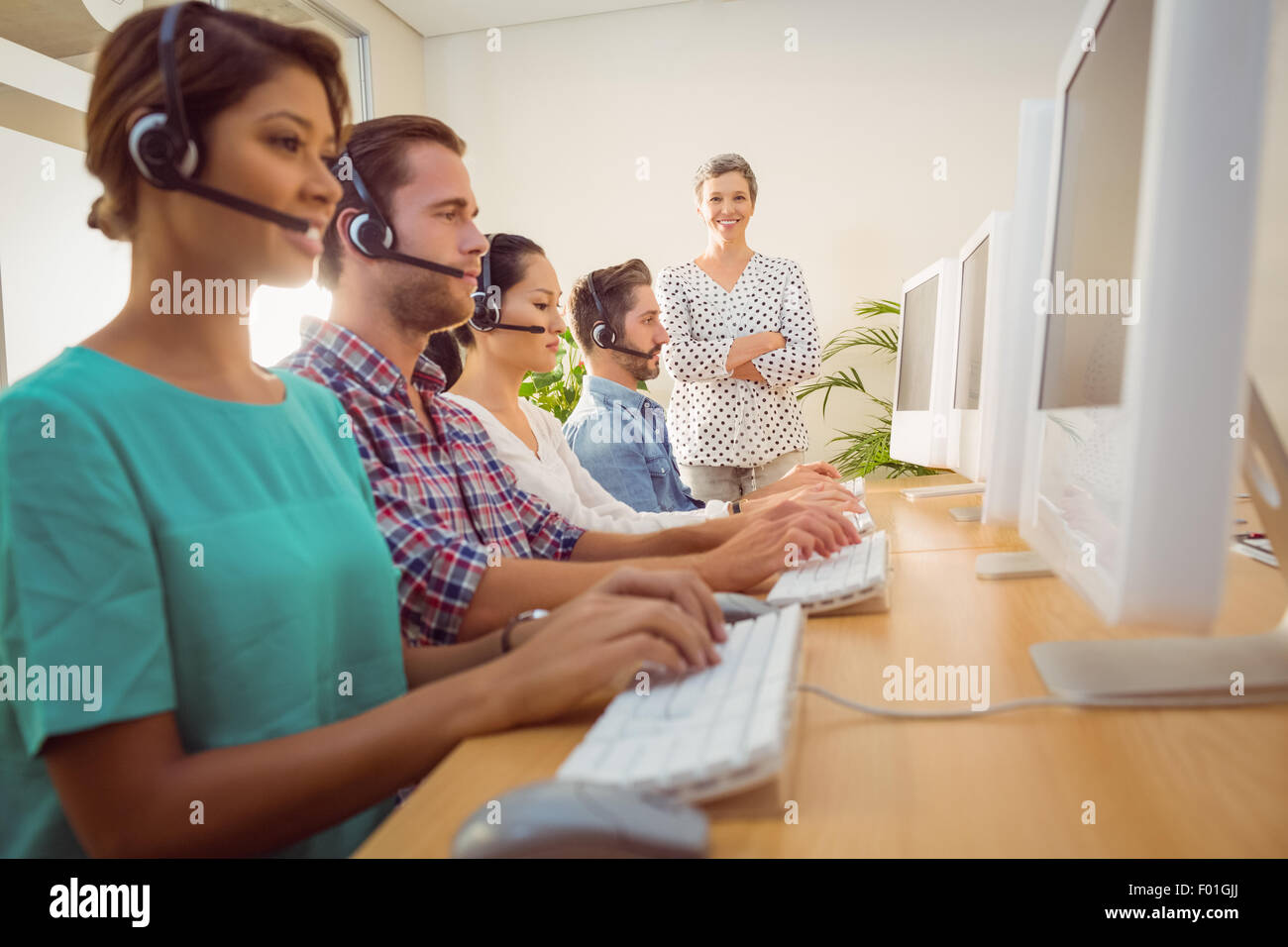 Manager supervising work in call center Stock Photo - Alamy