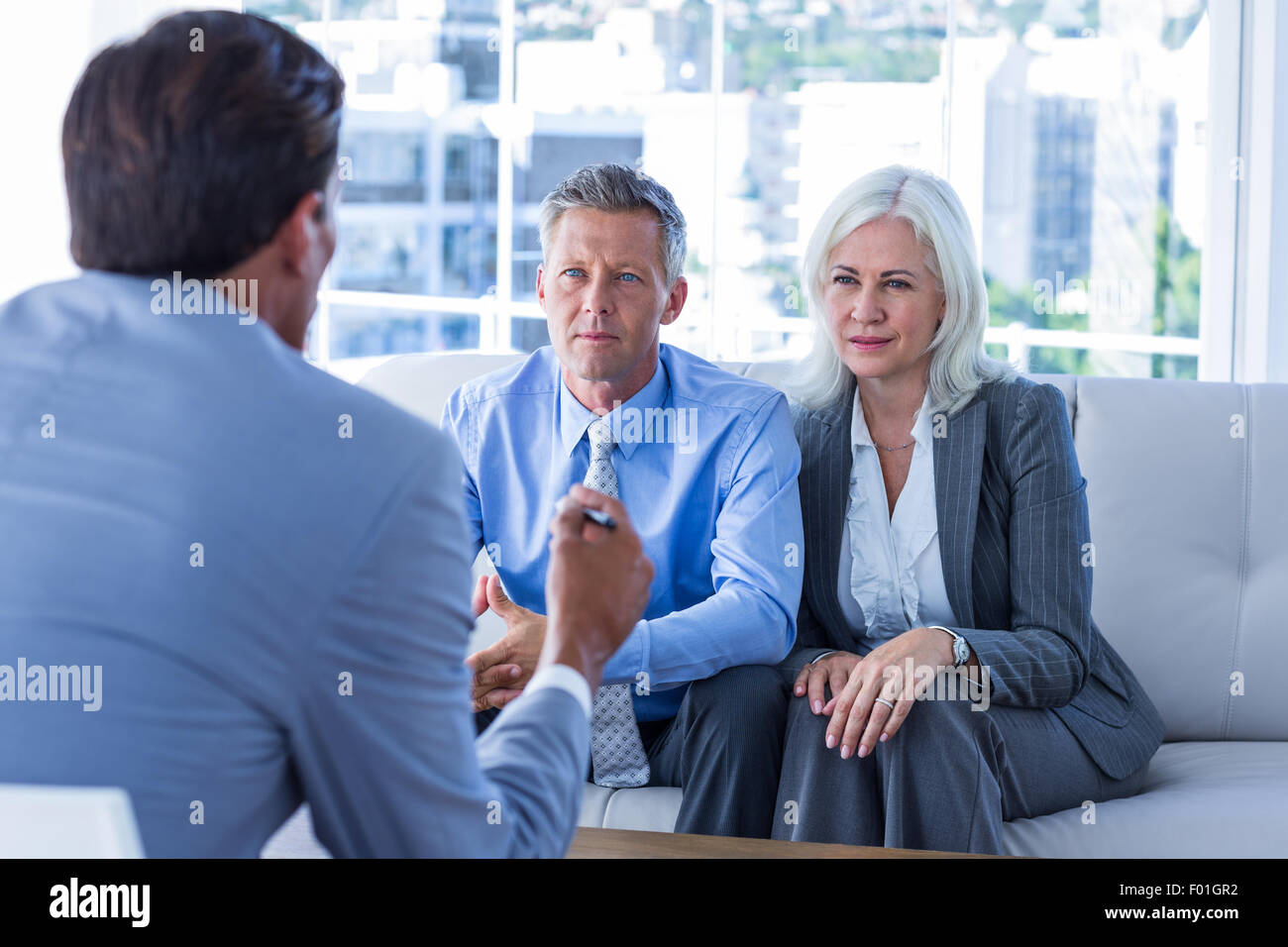 Business people speaking together on couch Stock Photo - Alamy